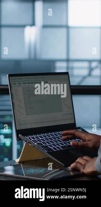 Vertical video Engineer in data center operating notebook, deploying ...