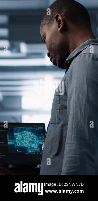 Vertical video Software developers in data center using laptop ...
