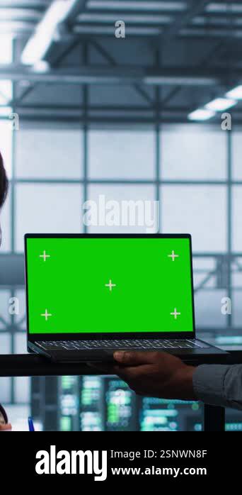 Vertical video Technicians in data center using green screen mockup ...