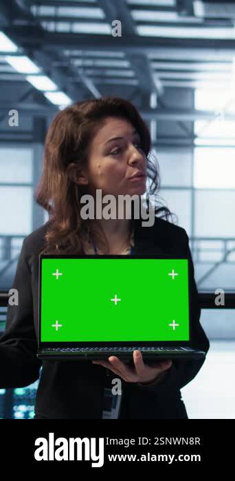 Vertical video Data center IT team automating routine maintenance tasks with green screen laptop ...