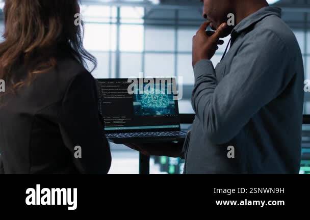 Software developers using AI tech on laptop in data center managing server virtualization. IT ...