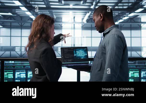 Software developers in data center using laptop, employing AI machine learning models. Workers ...