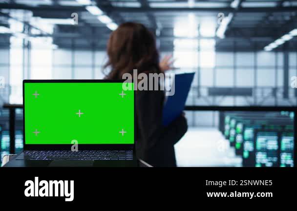 Mockup laptop in front of software developers walking in data center ...