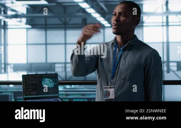 Computer scientist looking at holograms in data center, using artificial intelligence. African ...
