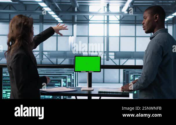 Data center team using mockup green screen tablet, reviewing paperwork ...