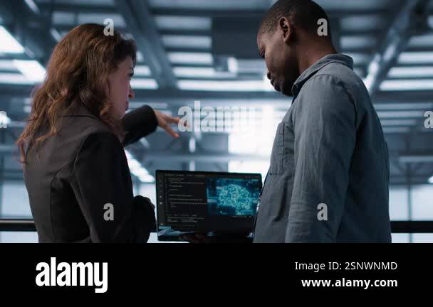 Software developers in data center using laptop, employing AI machine ...