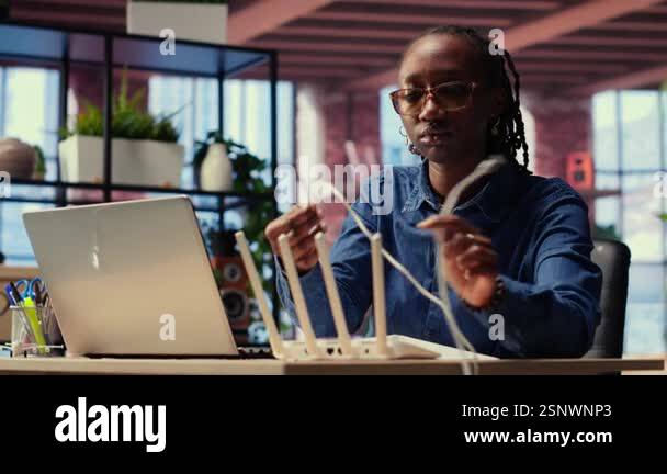 Black woman at home examines the modem and troubleshooting guide book ...
