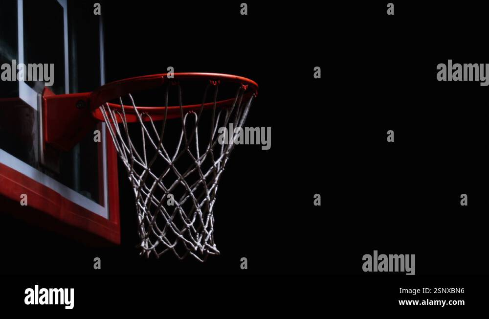Close up of a basketball falling through the net of the hoop for a ...