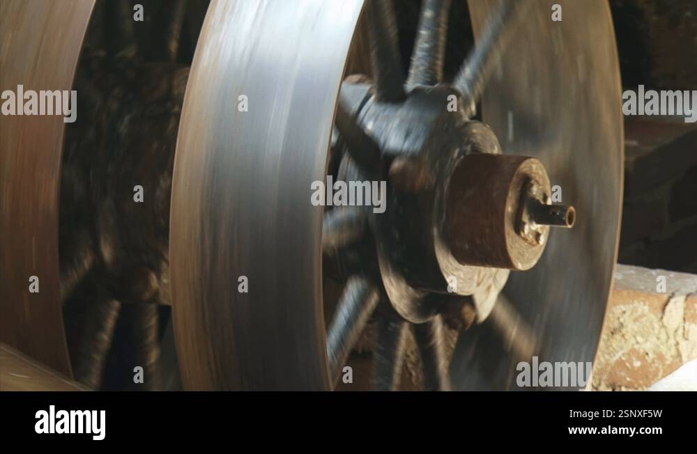 Industrial wheels rotate as part of a line shaft, a power driven ...
