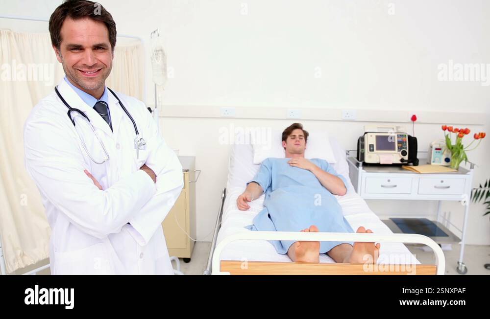 Sick man lying on hospital bed coughing with doctor smiling at camera ...