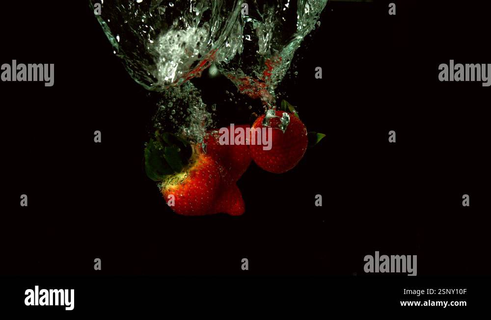 Strawberries falling in water on black background Stock Video Footage ...