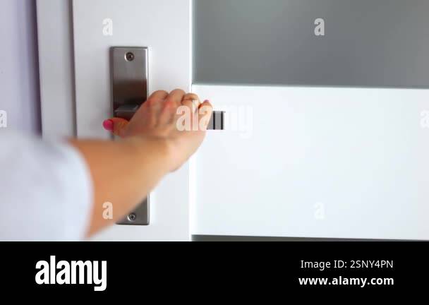 Woman hand opens wooden door with glass slightly by pushing down iron ...