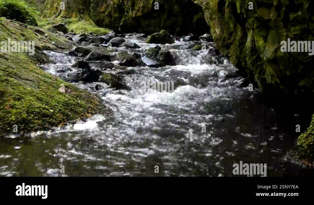 Spring small mountain stream, water is running at basalt rock Stock ...