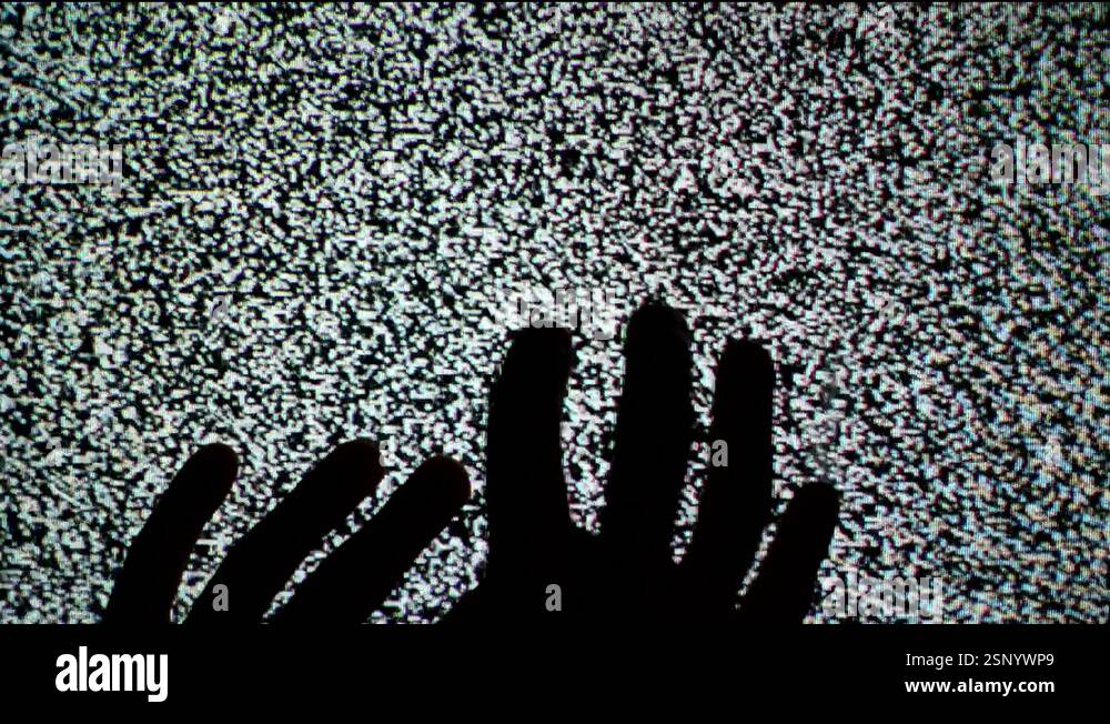 Male hands crawling up the TV screen with static television noise as ...