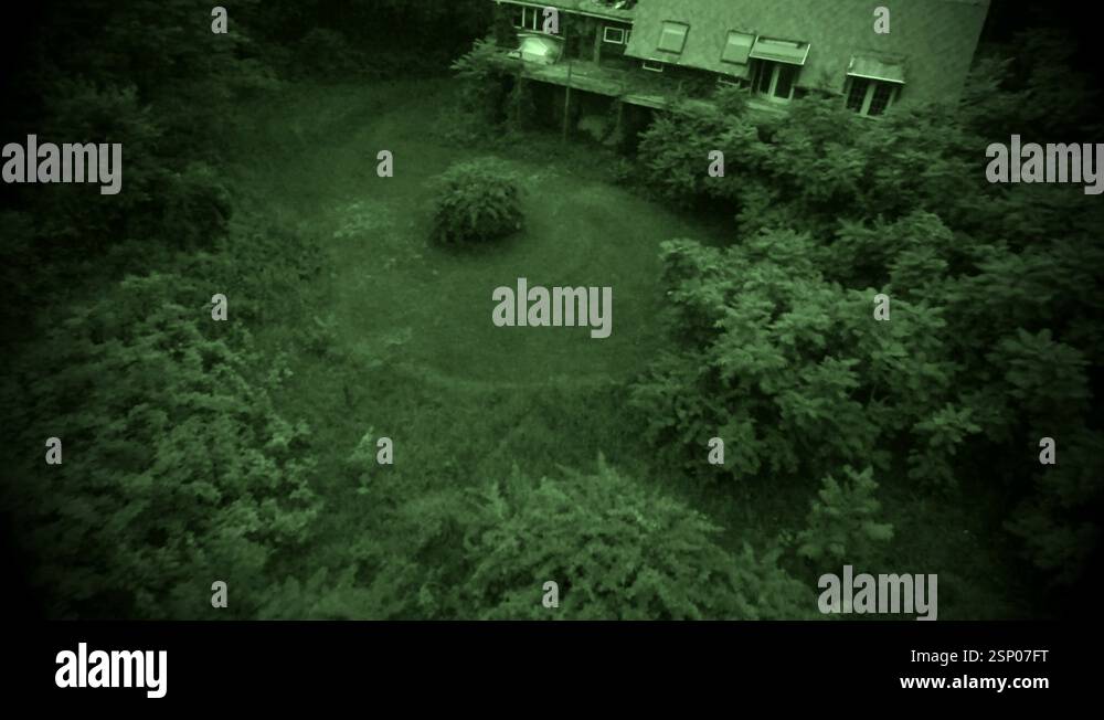 Night vision in air flight above wooden neglected abandoned farm house ...