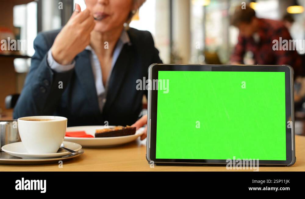 tablet green screen - woman eats cake and drinks coffee in cafe Stock ...