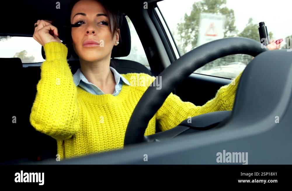 Cute lady putting makeup while driving car Stock Video Footage - Alamy