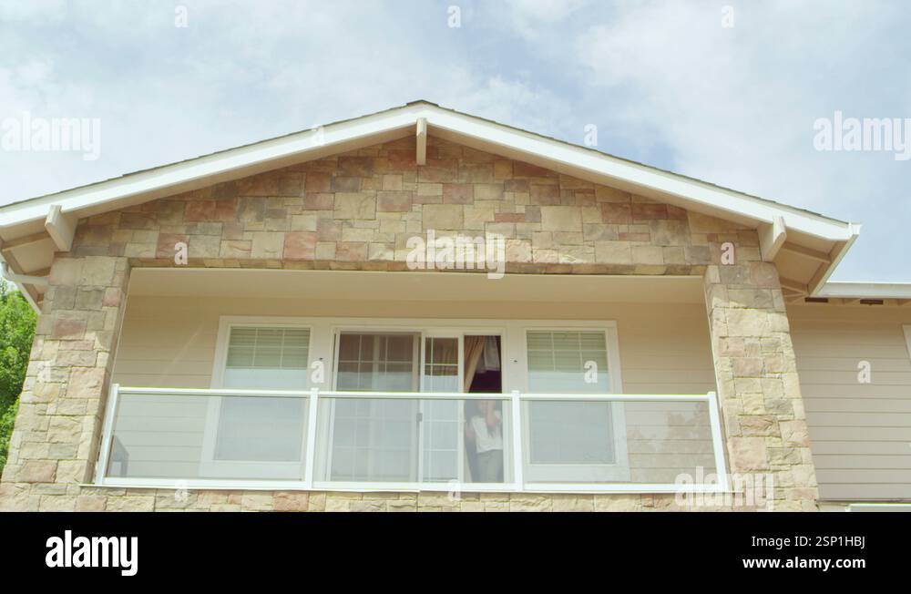 Two sisters come outside to stand on their balcony and hug Stock Video ...