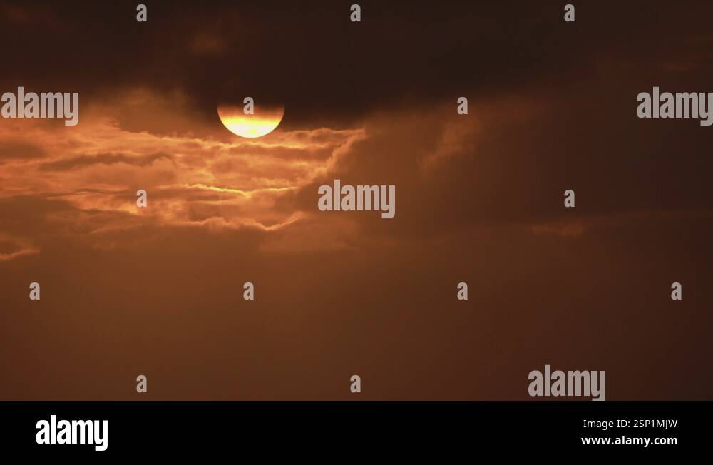 Real time aerial setting sun hides/emerges behind clouds and heavy fog ...