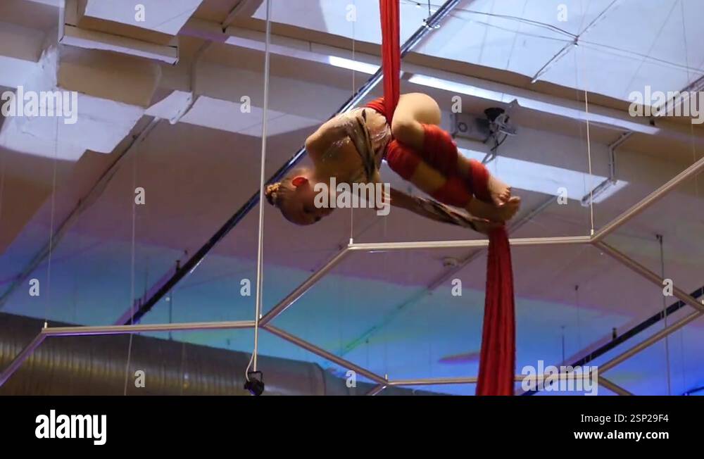 circus trick little girl shows a number on the fabric from the ceiling ...