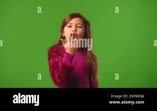 Children emotions concept. Smiling girl child looks at camera and blows ...