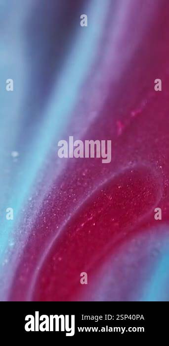 Vertical video. Glitter fluid spill. Bokeh light. Defocused shimmering red blue color sand ...