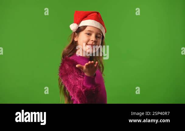 Children emotions concept. Smiling girl child in santa hat blows an air ...