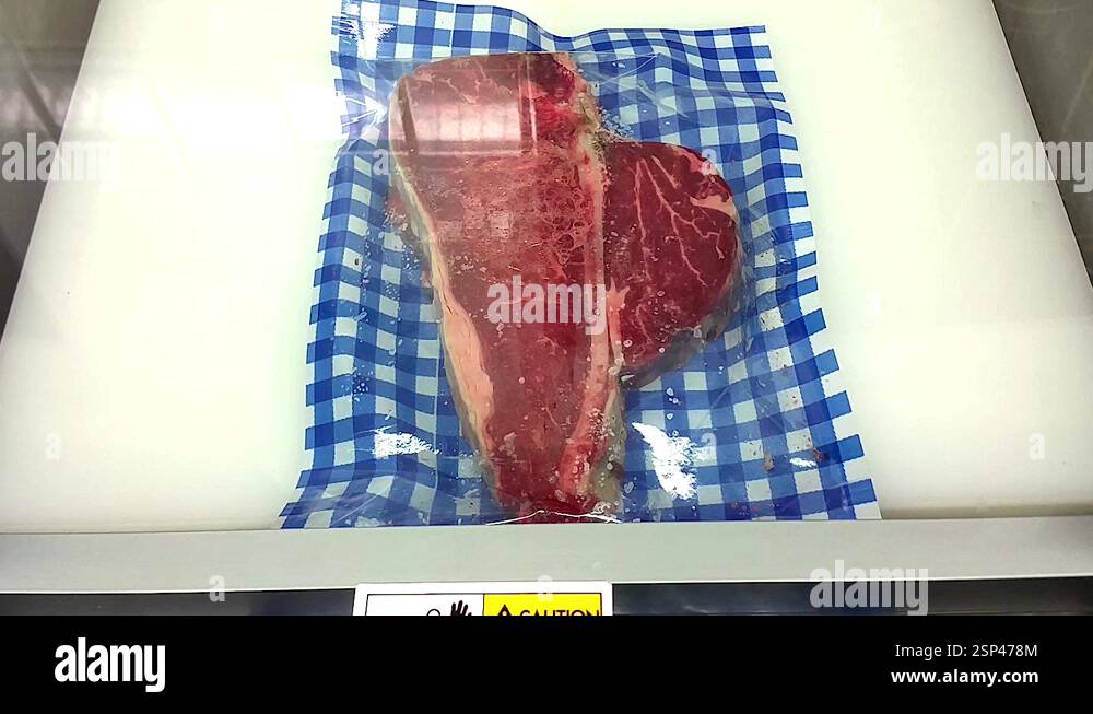 Vacuum packing I-bone steaks, in a vacuum machine, at a restaurant ...