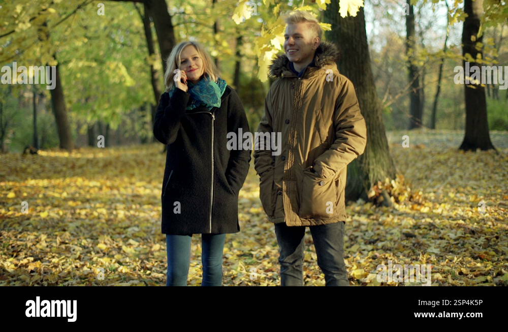 Girl talking on cellphone in the park and her boyfriend relaxing Stock ...