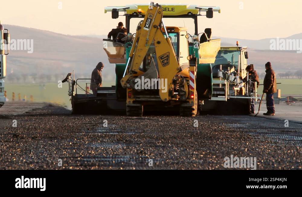Tracked paver laying fresh asphalt pavement Stock Video Footage - Alamy
