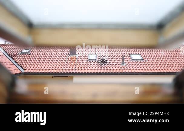 View from a roof window of a rainy day on the rooftops of the suburbs ...