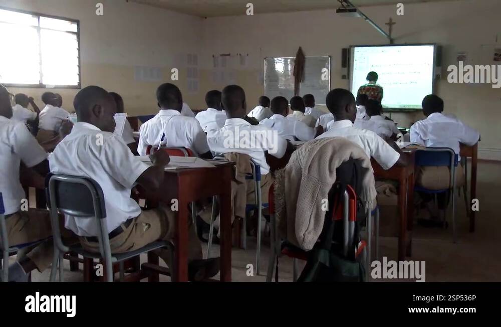 African woman teacher writing on a smart board at school-Modern ...