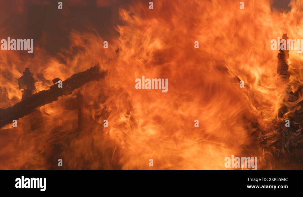 Flames devour the last charred rubble of a house destroyed by fire ...