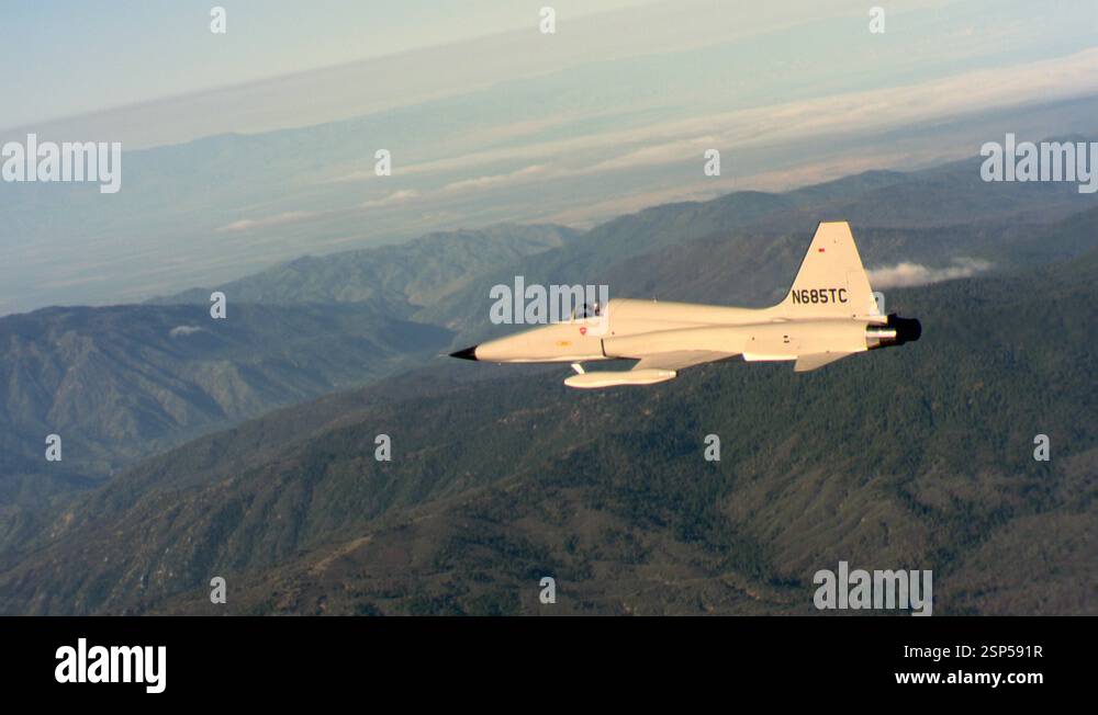 A Northrop F-5A fighter jet flying above barren mountains Stock Video ...