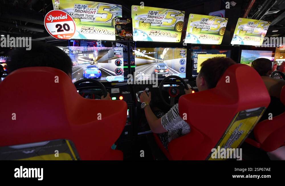 Kids playing arcade video game at an amusement park in MBK mall Stock ...