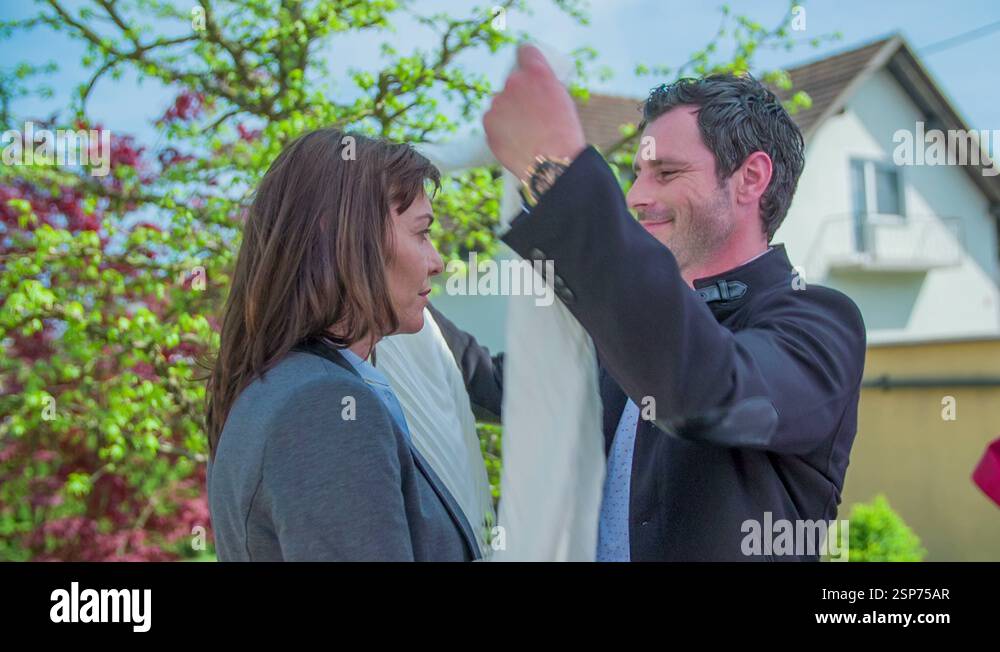 Putting a white scarf across his wife's neck and then touching ...