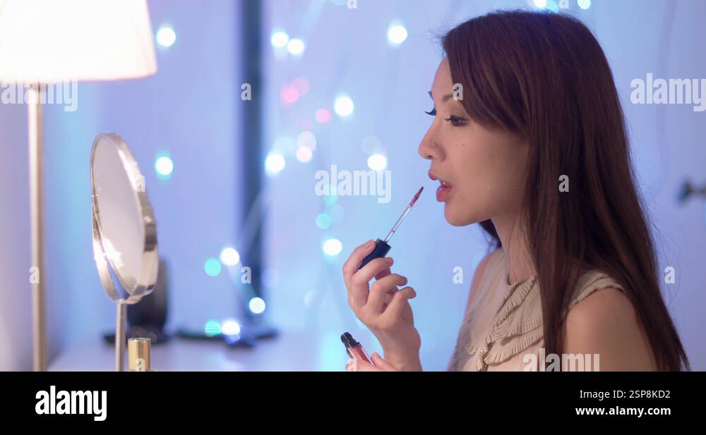 Beautiful Asian woman putting on lipstick at dressing table 4K Stock ...