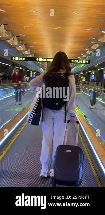airport girl suitcase Footage of passengers on moving walkway to gates ...
