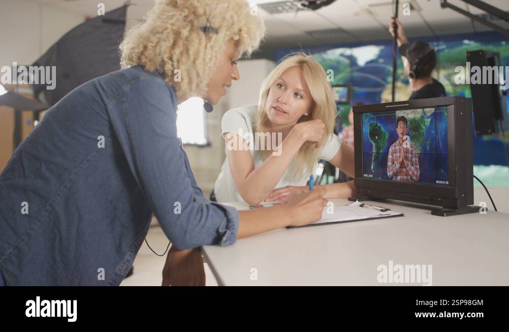 4K Crew members having a discussion behind the scenes on TV studio set ...