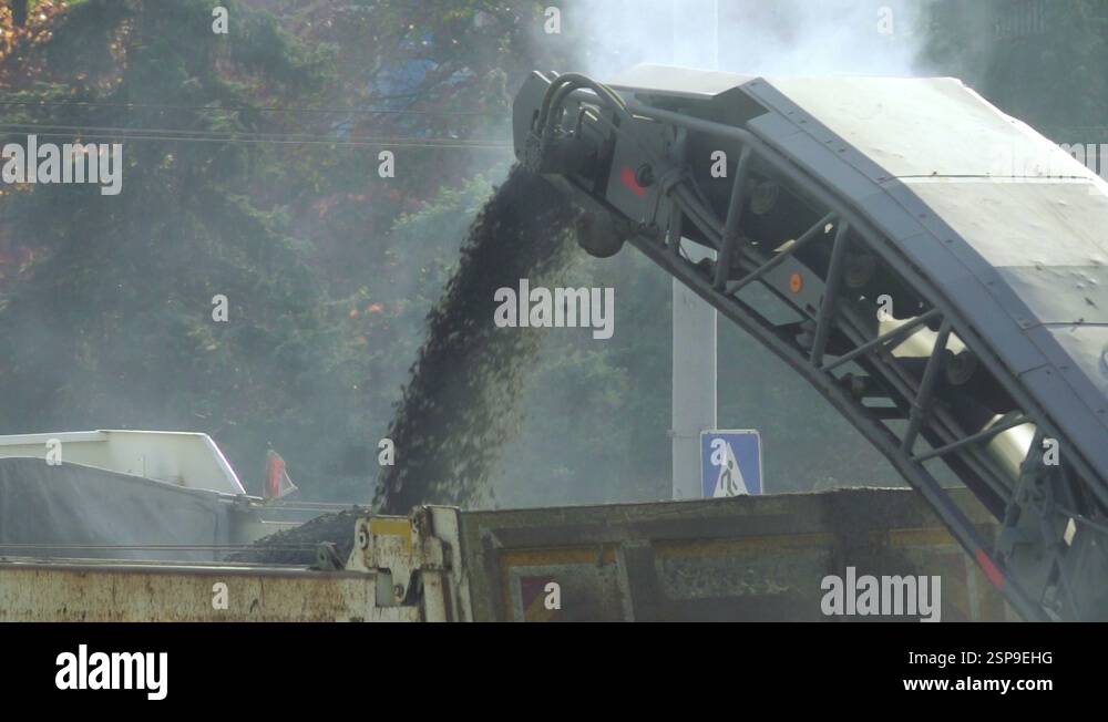 Cold milling machine, milled asphalt goes the conveyor belt slow motion ...