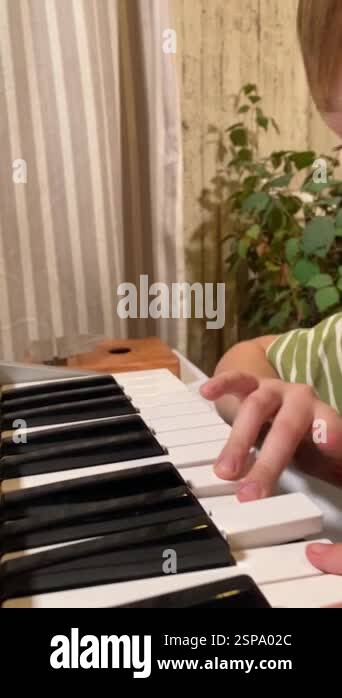 Vertical a young music teacher guides a child in learning to play the ...