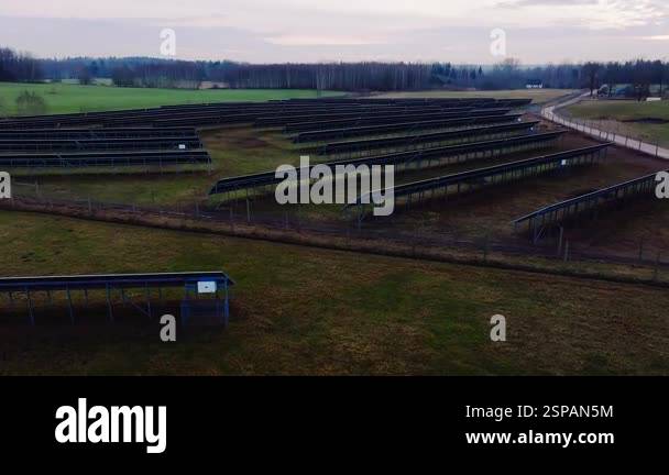 Solar farm featuring rows of metal framed panels on a grassy field, a ...