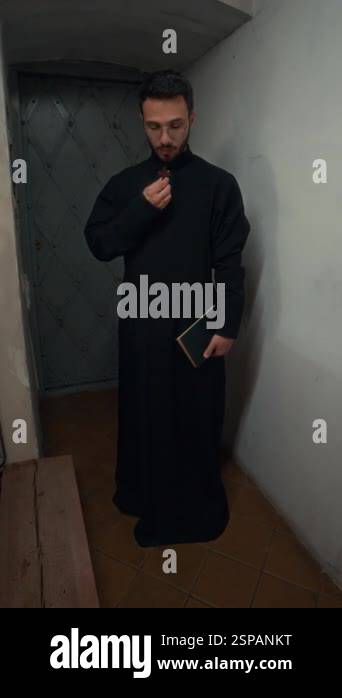 Vertical full-length portrait of Middle Eastern young pastor with bible ...