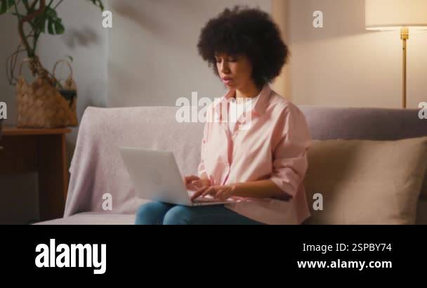 Busy Latin woman works from home typing on laptop in living room. Young ...
