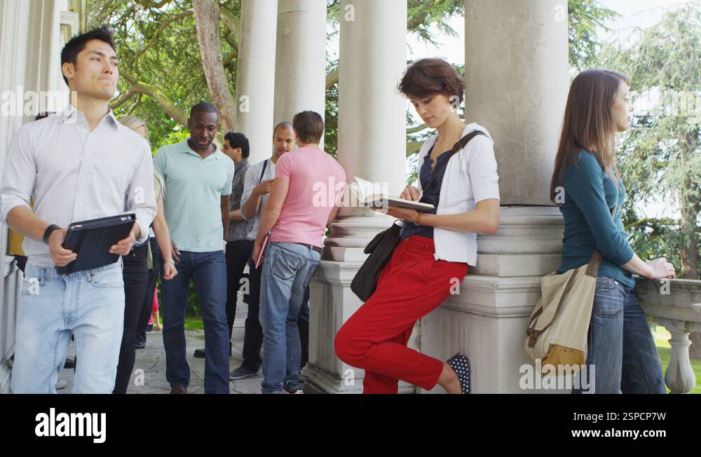 4K Diverse student group taking a break between classes outside college ...