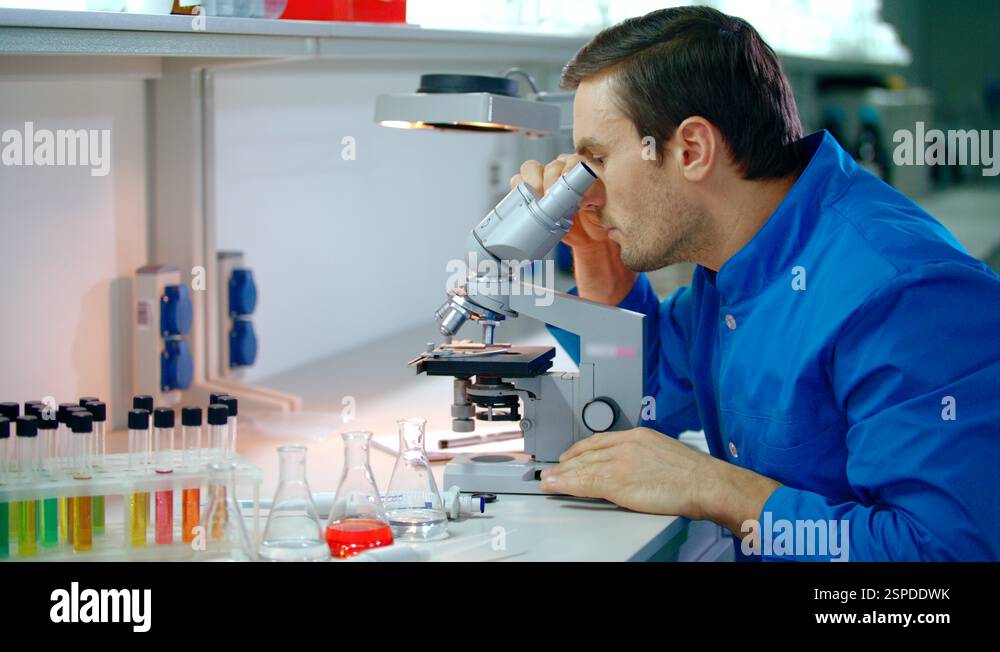Male scientist doing microscope research. Man scientist looking ...