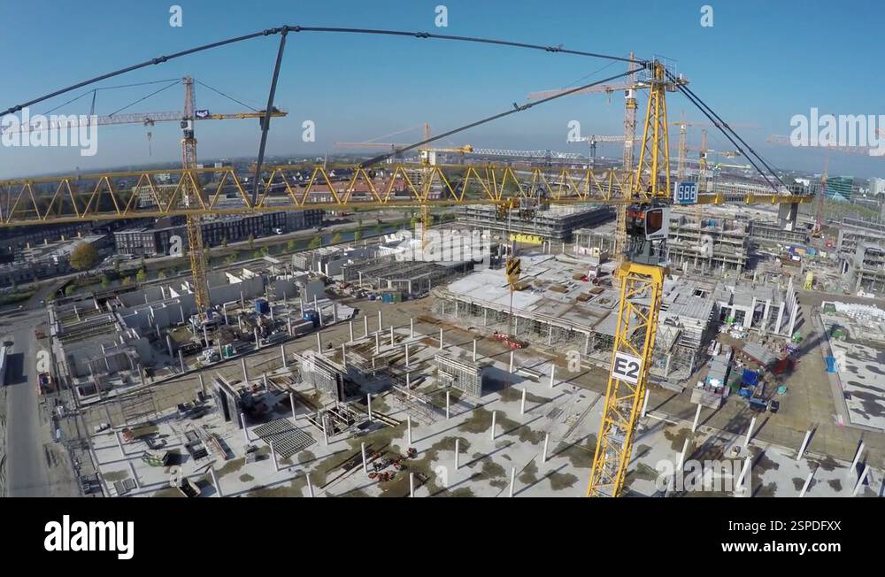Aerial bird view of construction site moving up showing yellow tower ...