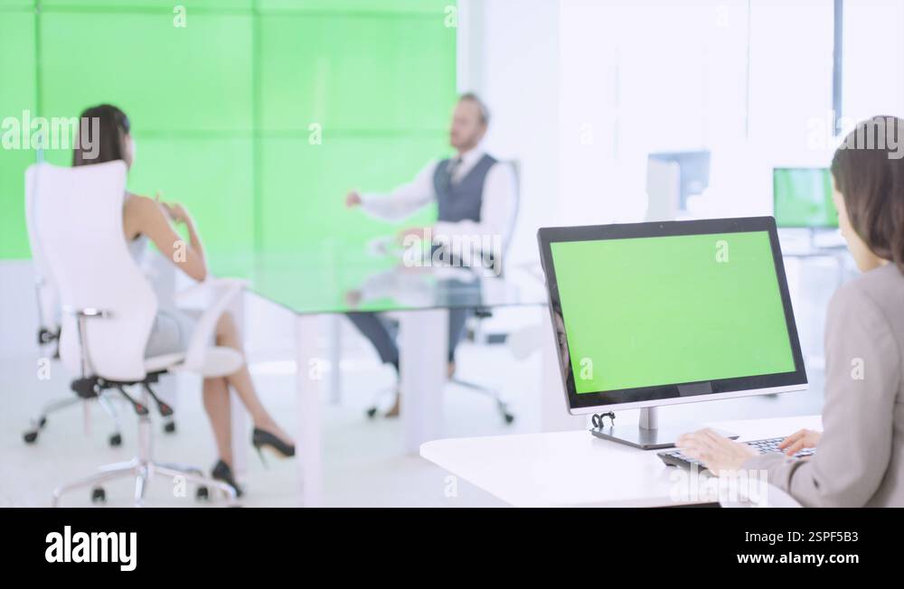 4K Business team in modern office green screen on video wall & computer ...