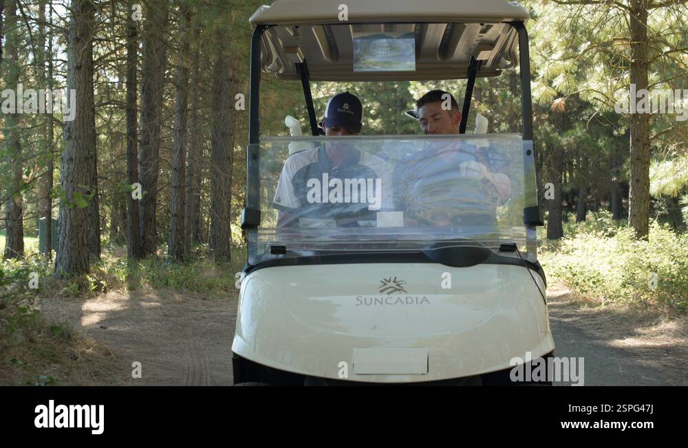 Two men riding in a golf cart in a resort Stock Video Footage - Alamy