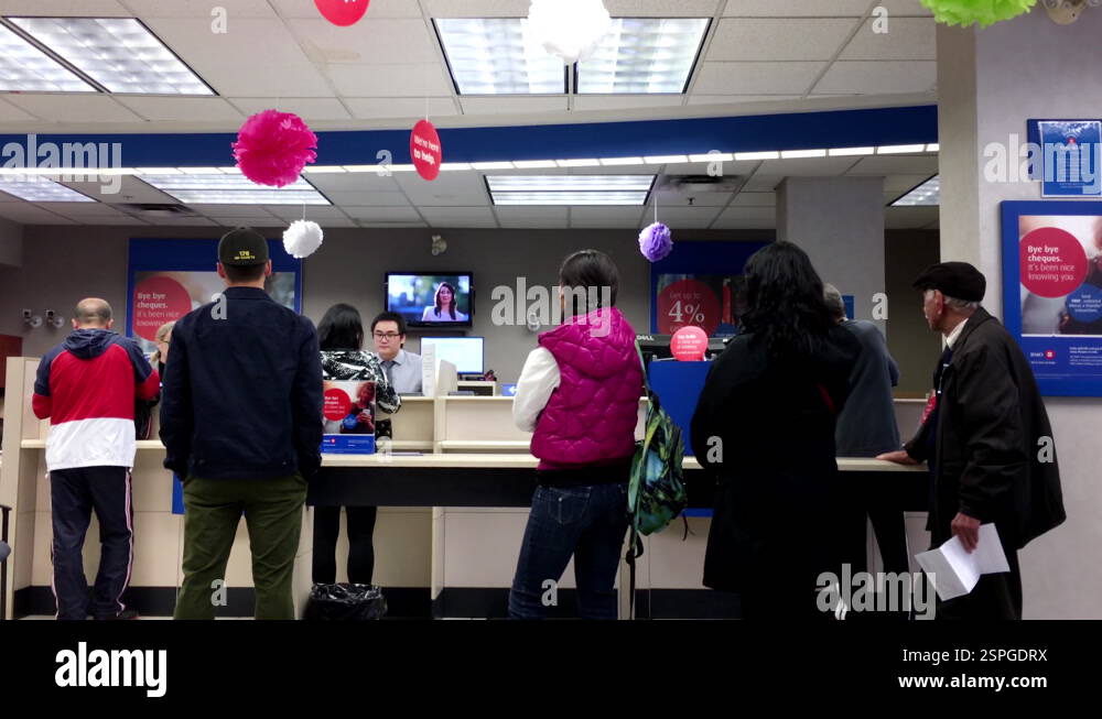 People at service counter talking to the teller inside BMO Bank Stock ...